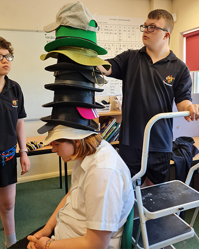 Students stack 15 hats on teacher's head to break record | Guinness ...