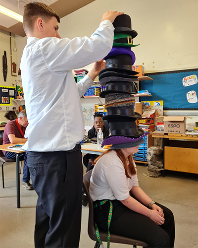 Students stack 15 hats on teacher's head to break record | Guinness ...