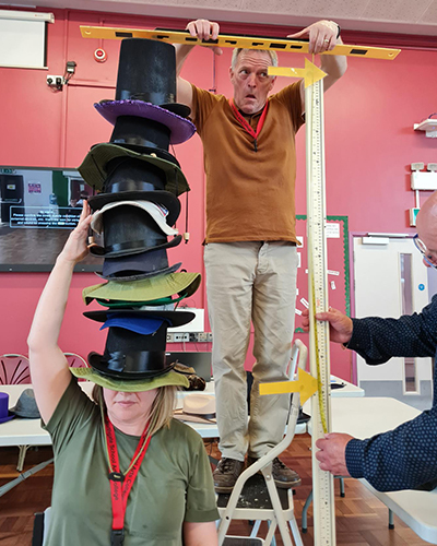 Students stack 15 hats on teacher's head to break record | Guinness ...